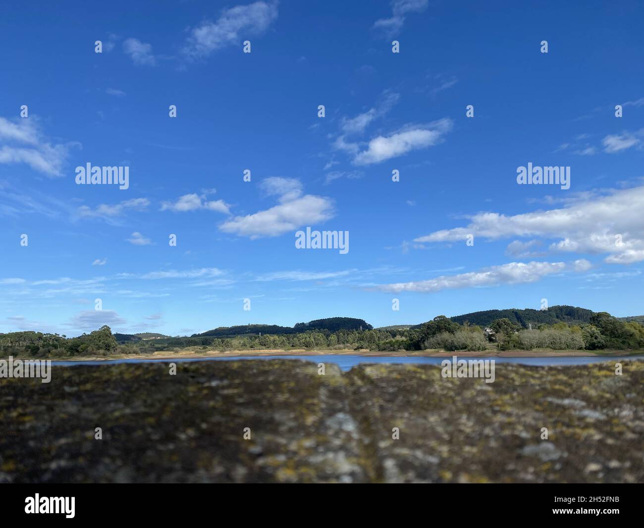 Beautiful scene low angle of blue water, green hills under a blue ...