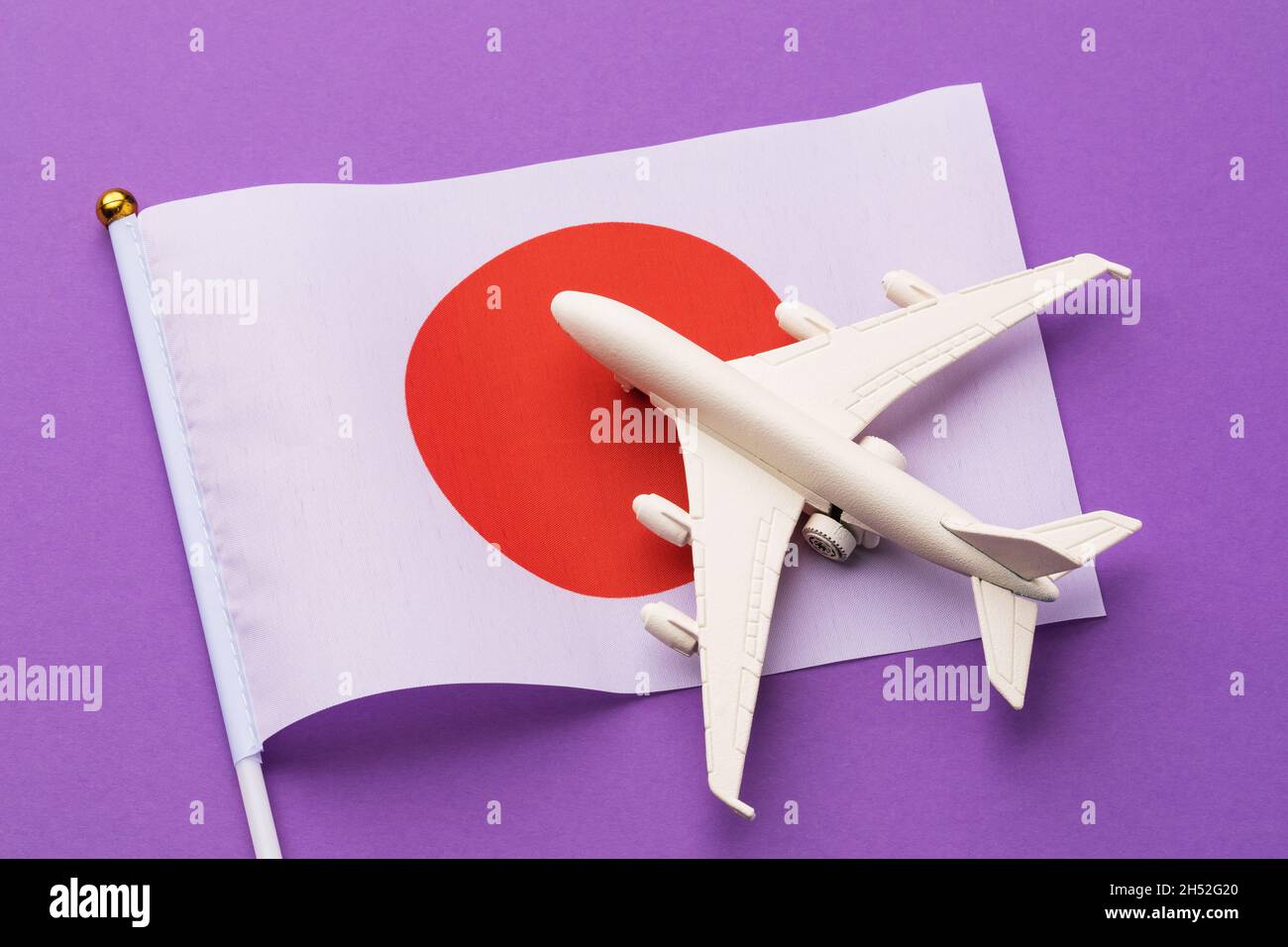 Japan flag and toy plane on a purple background, concept on the theme ...