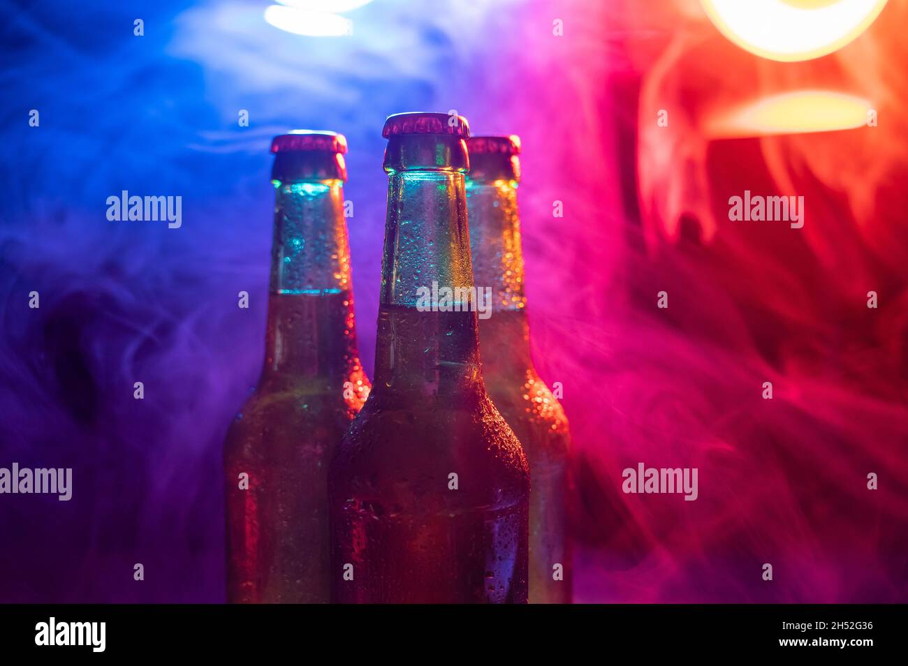 Three bottles of beer in a blue-pink mist Stock Photo - Alamy