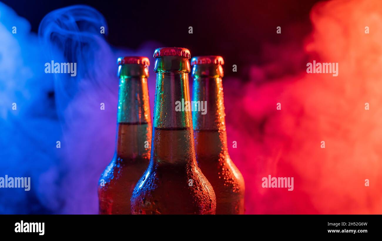 Three bottles of beer in a blue-pink mist Stock Photo - Alamy