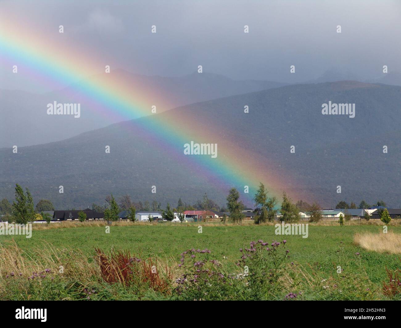 Rainbow over a rural area with scenic hils Stock Photo - Alamy
