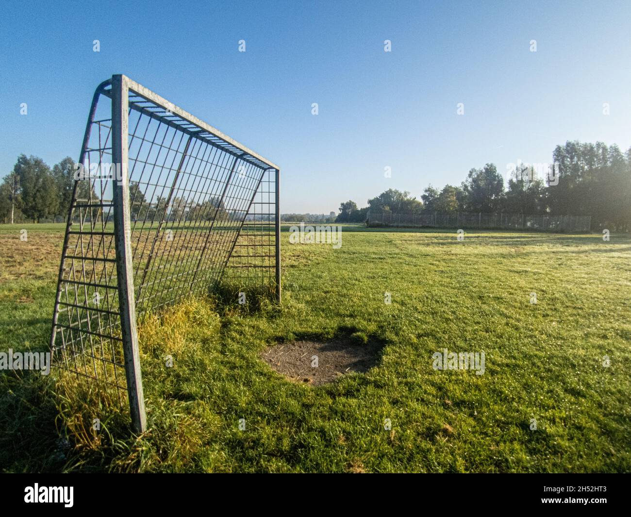 Football net in a sunny field surrounded by trees Stock Photo - Alamy