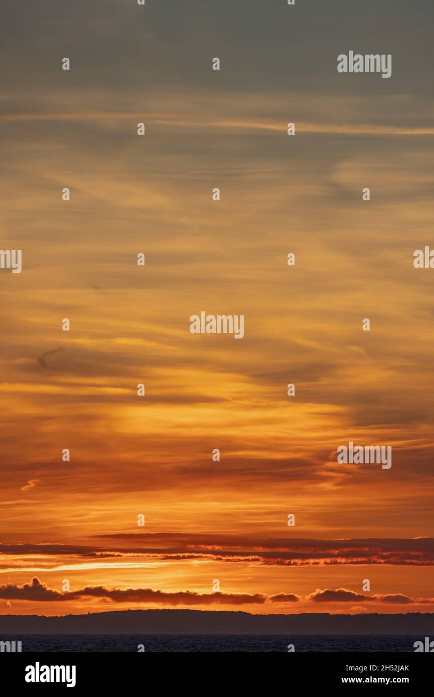 The setting sun lighting up the cloud cover Stock Photo - Alamy