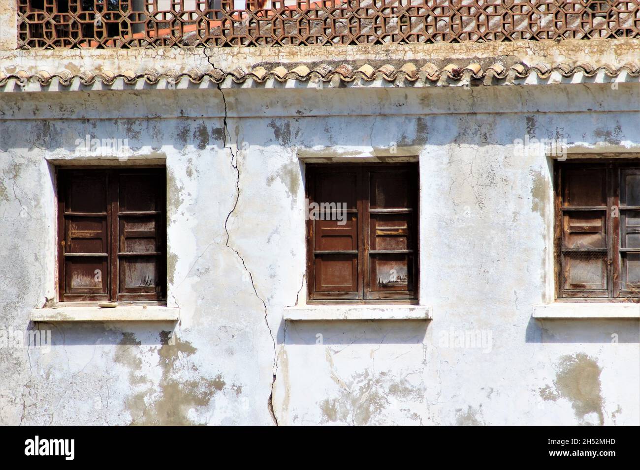 Old shuttered windows in a cracked whitewashed wall, Spain Stock Photo ...