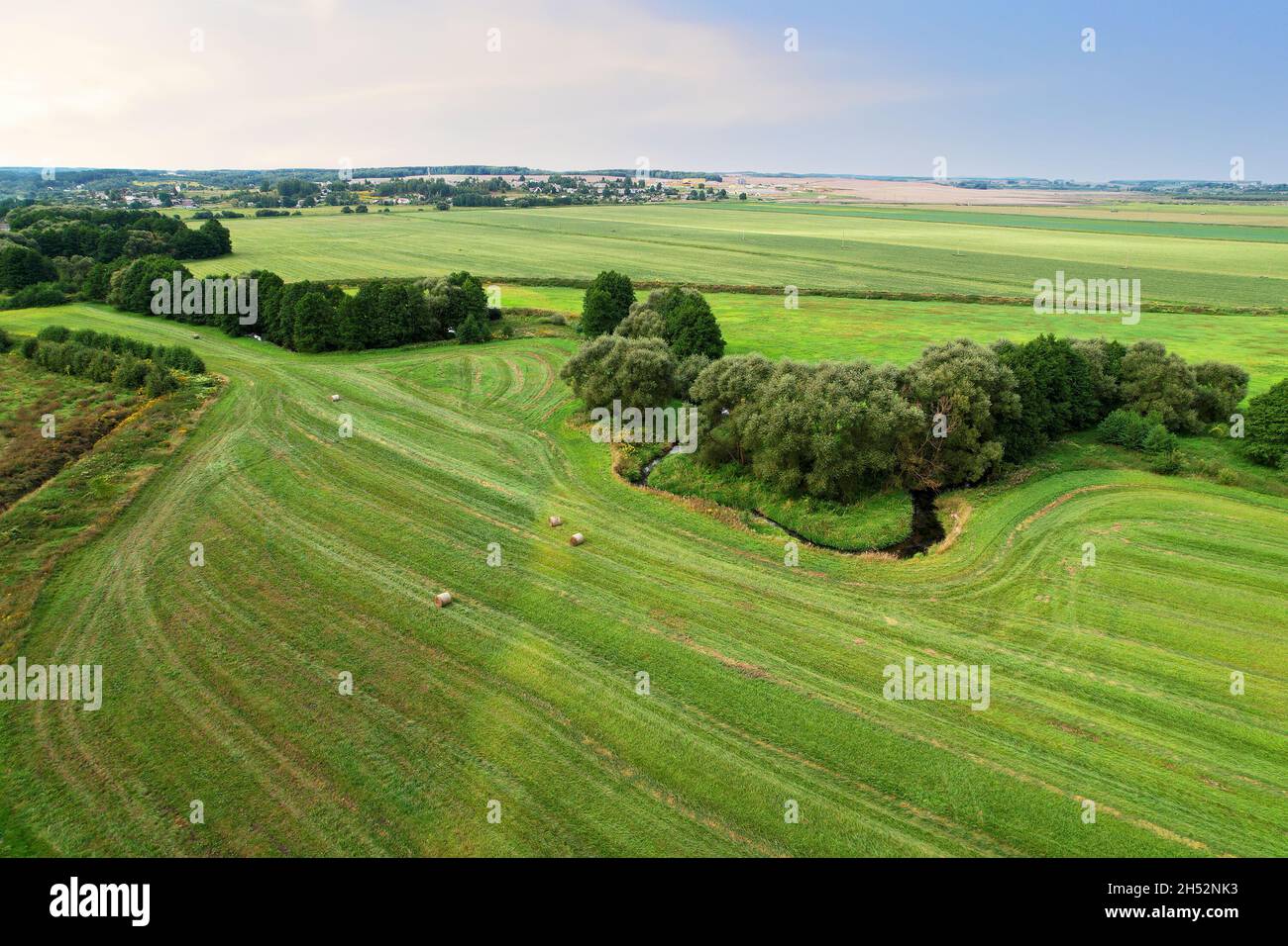River in the wild. Aerial view of small river in middle of green field ...