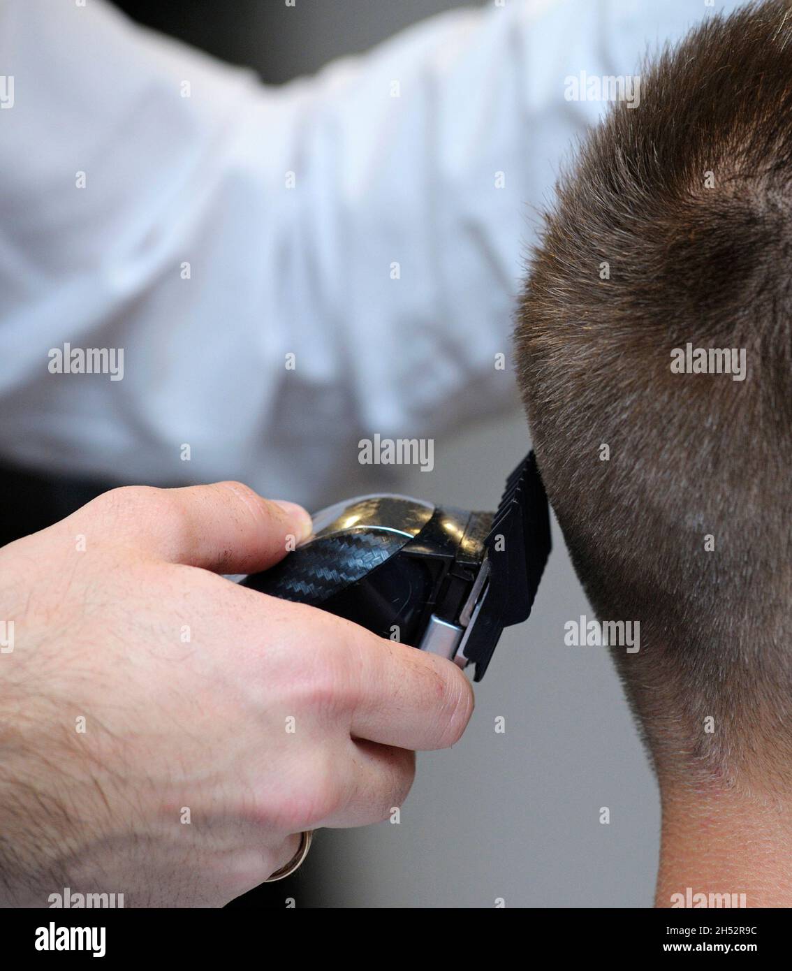 Barbershop. Barber hand cutting customer hair with a hairclipper Stock ...