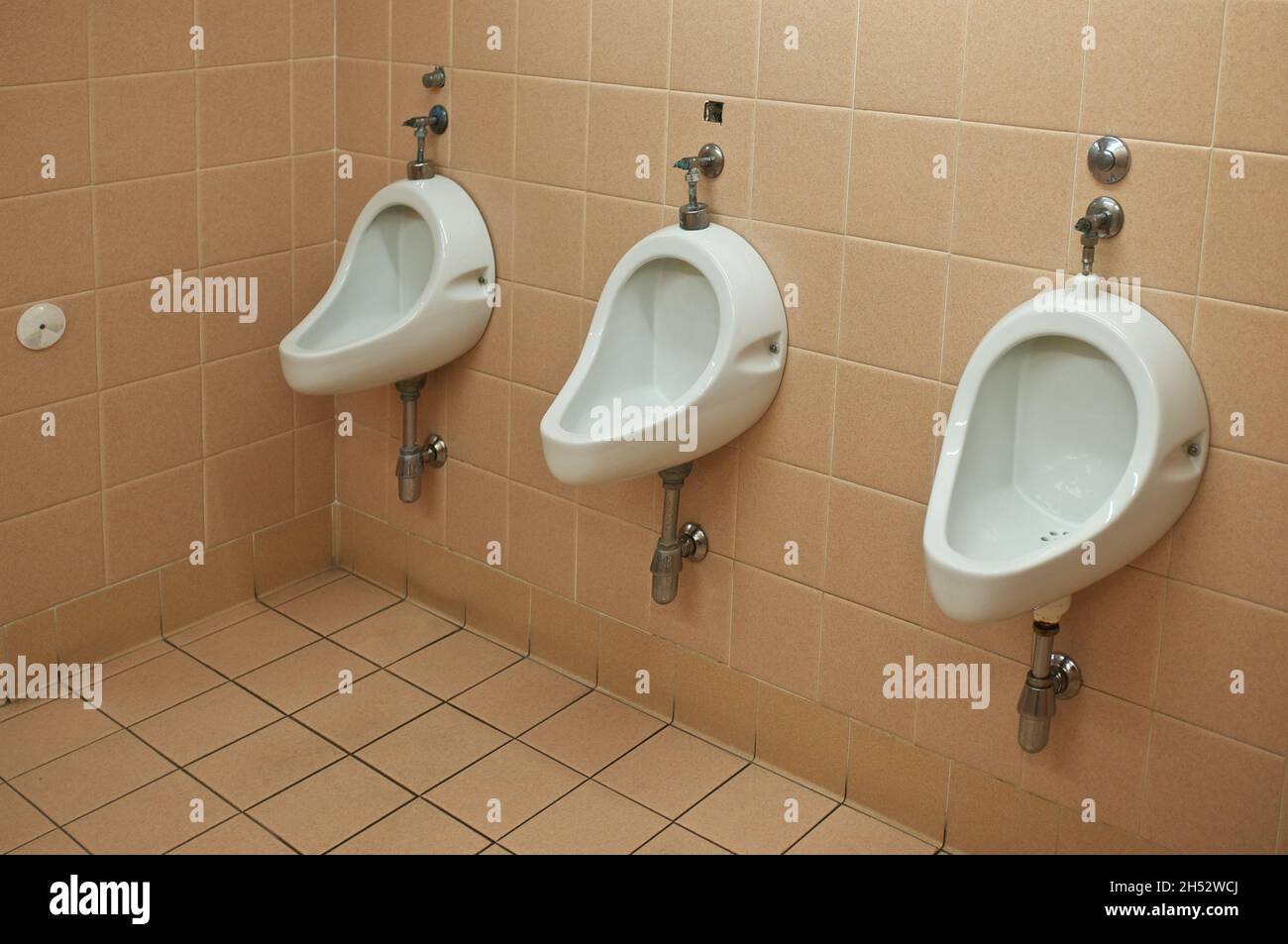 Three men urinals in the public restroom Stock Photo - Alamy