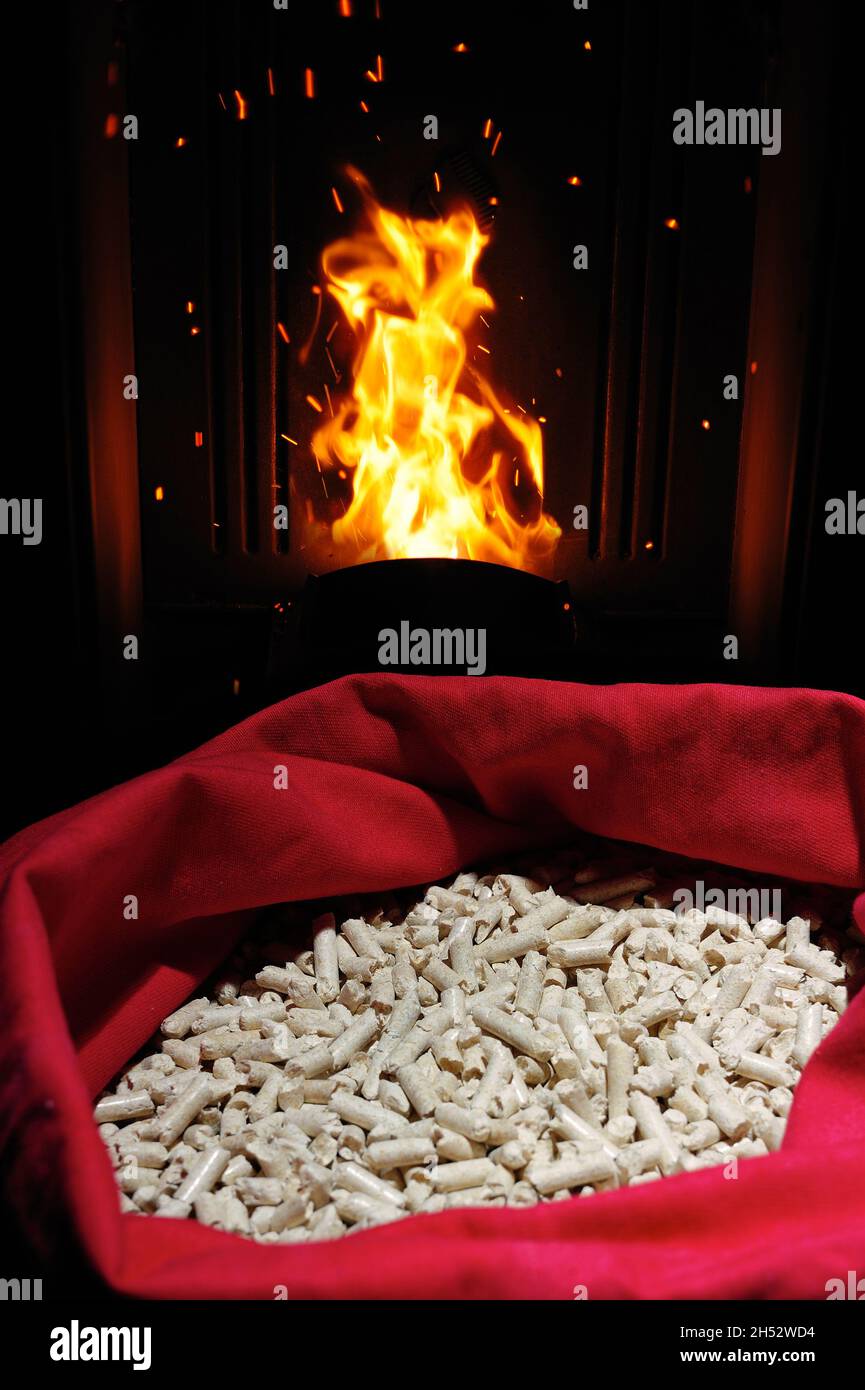 wood pellets in canvas sack, with stove and flame Stock Photo - Alamy