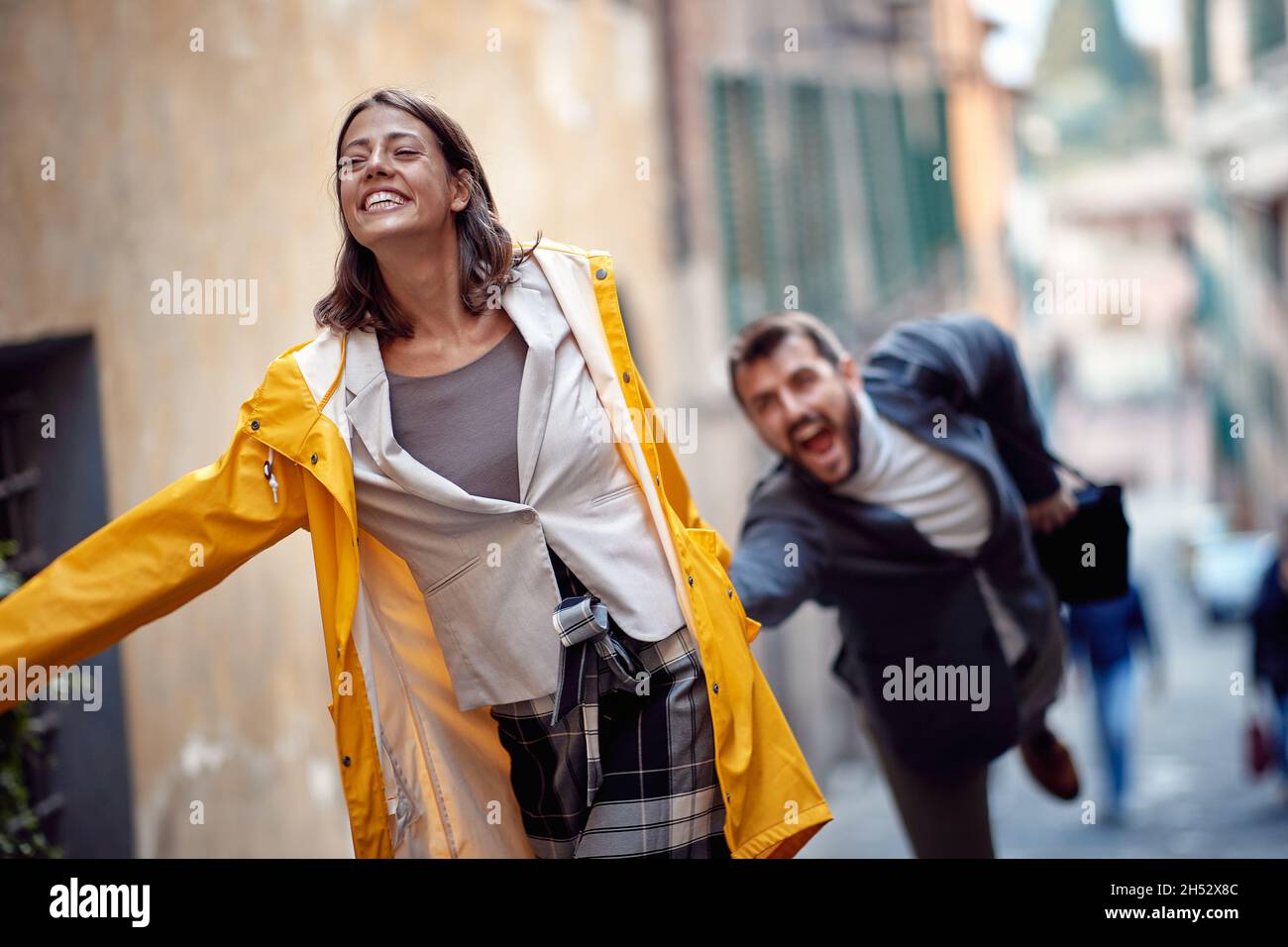 A young happy couple is having fun while walking the old city in a ...