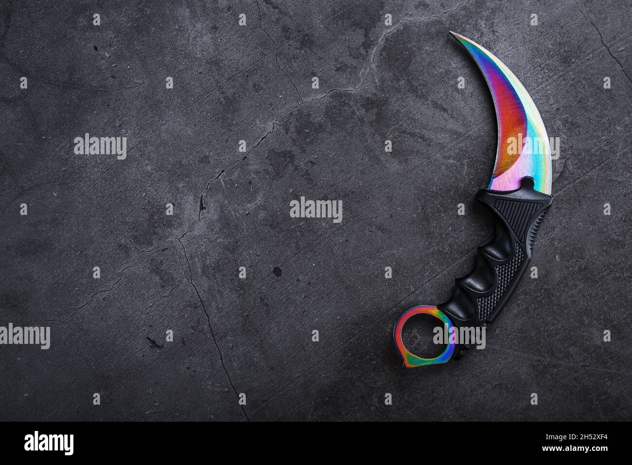 A dagger with a steel blade with a gradient color on a black background ...