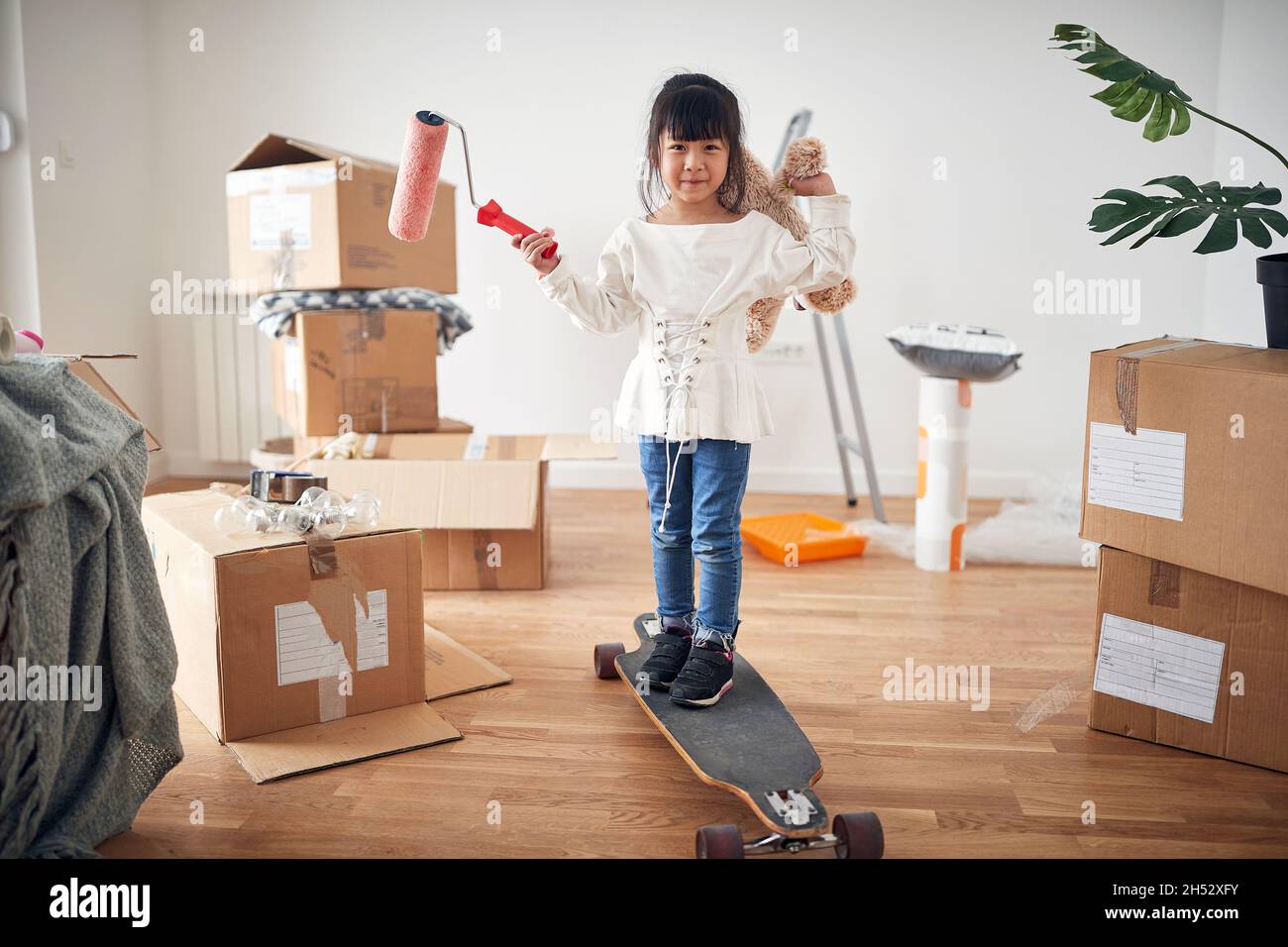 Little japanese cute girl and cardboard boxes moving in a new home ...