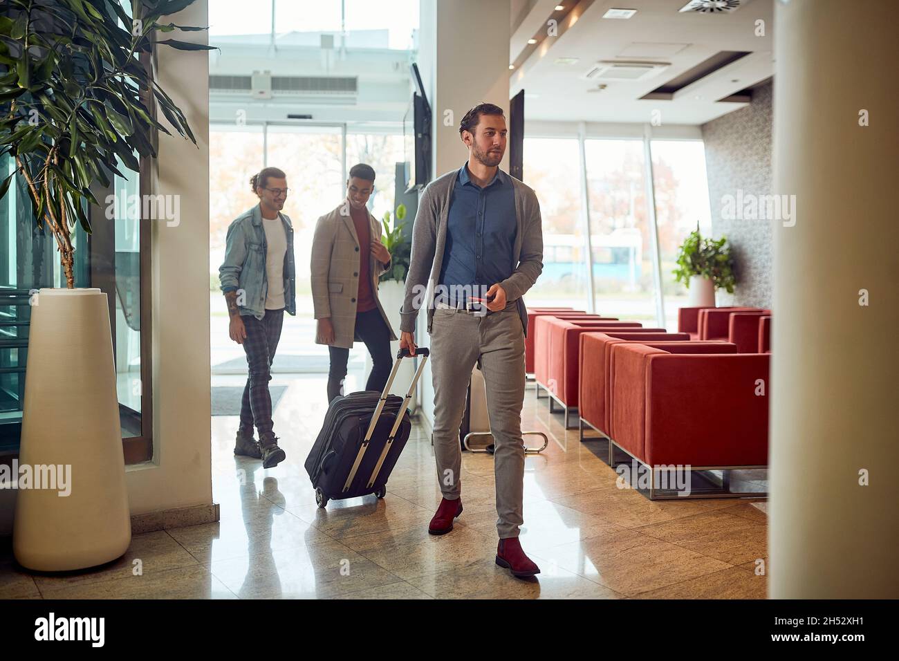 Man carrying luggage in the lobby of a hotel.Business people with ...