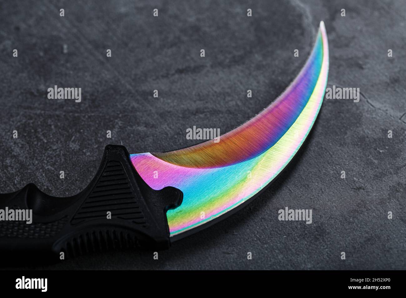 A dagger with a steel blade with a gradient color on a black background ...