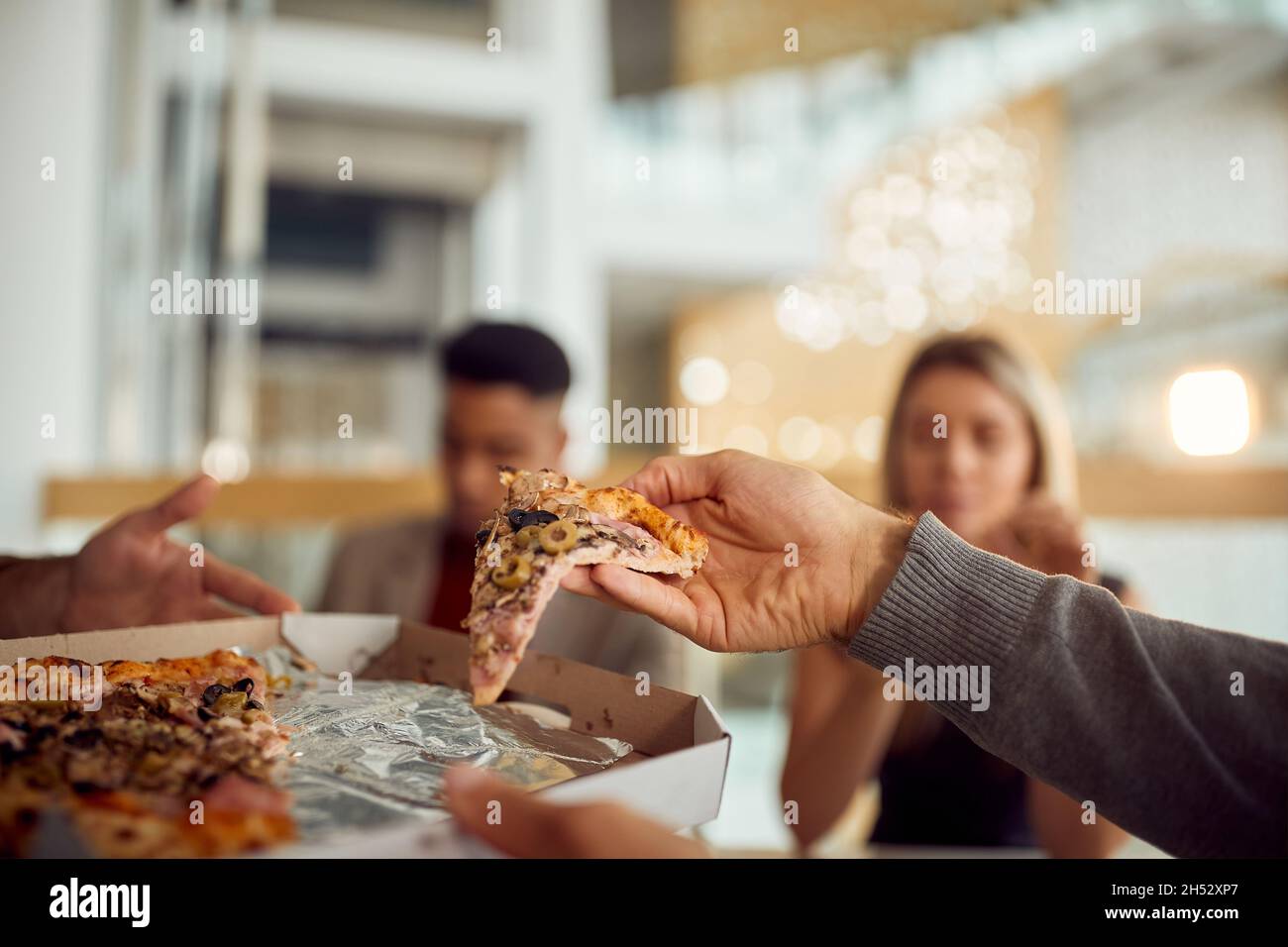 slice of pizza-eating pizza in office at break Stock Photo - Alamy