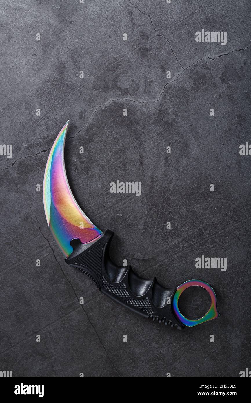 A dagger with a steel blade with a gradient color on a black background ...