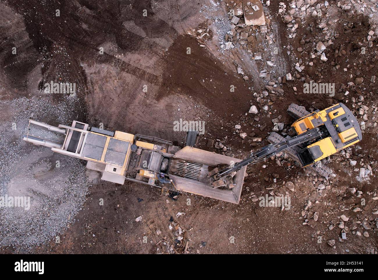 Excavator loading old concrete into stone jaw crusher. Stone crushing ...