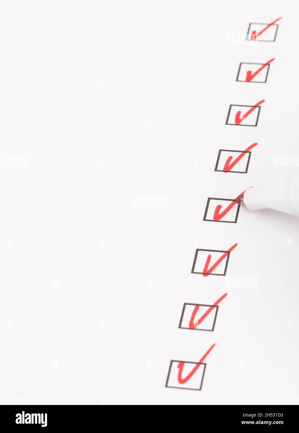 Red colored checkmarks in little black boxes, white paper, education ...