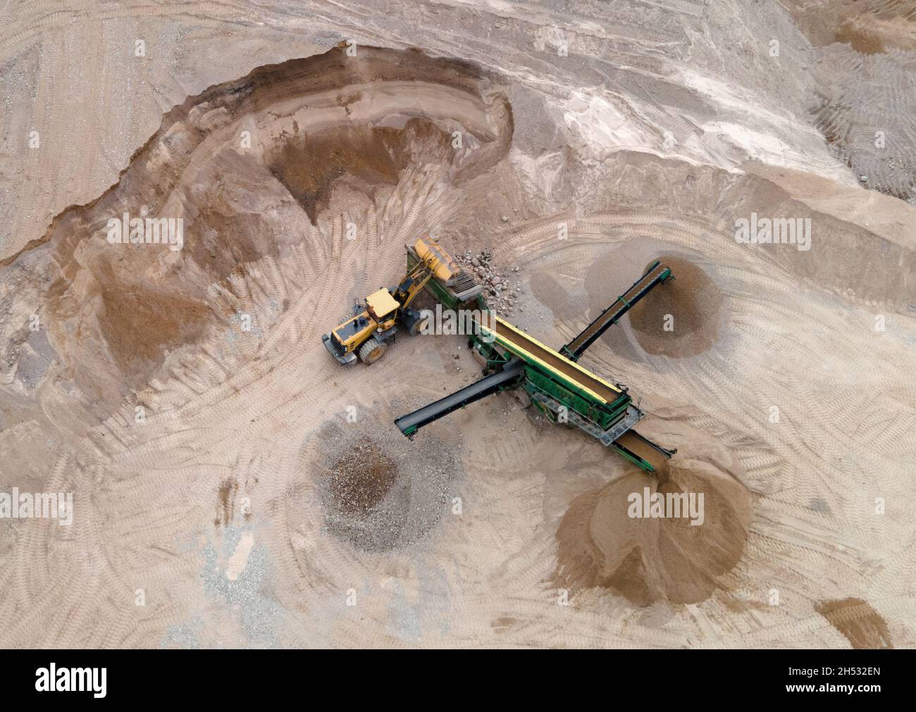 Arial view of the open pit mine. Front end loader loading gravel into ...