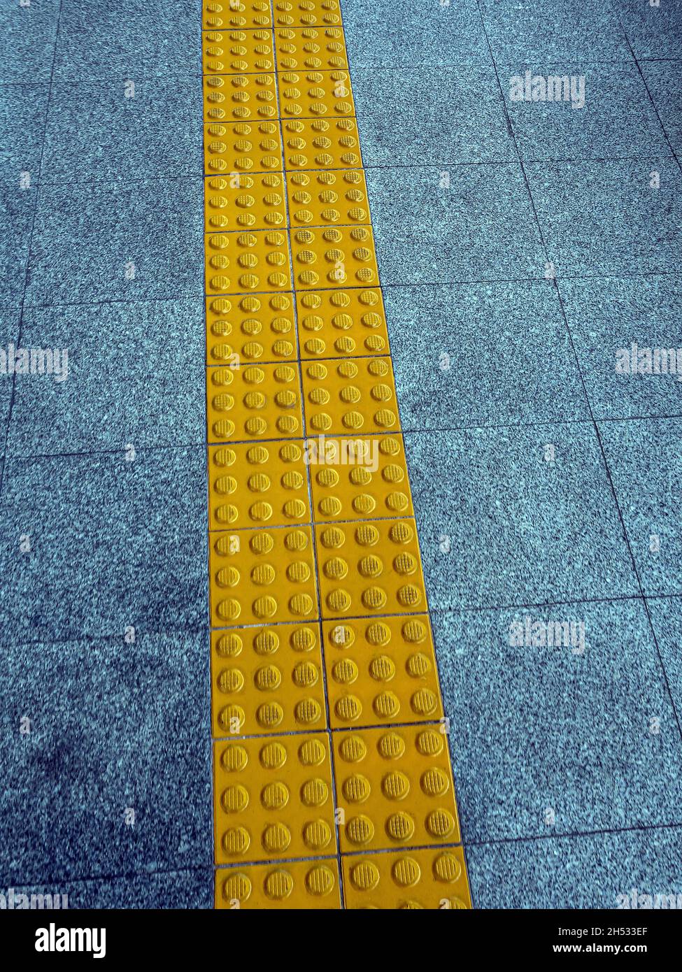 The yellow pavement has a textured surface to serve as a walking guide ...