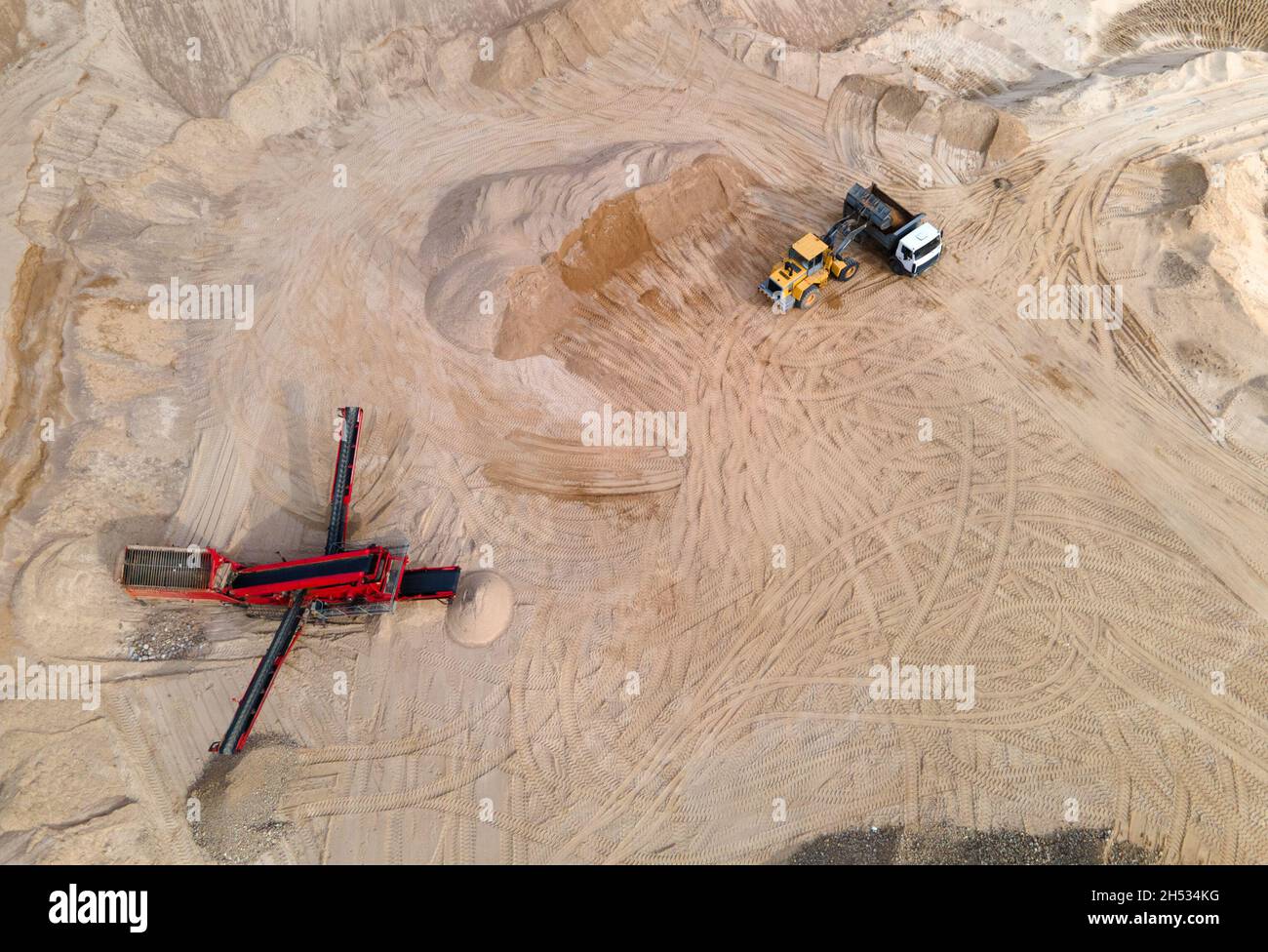 Arial view of the open pit mine. Front end loader loading gravel into ...