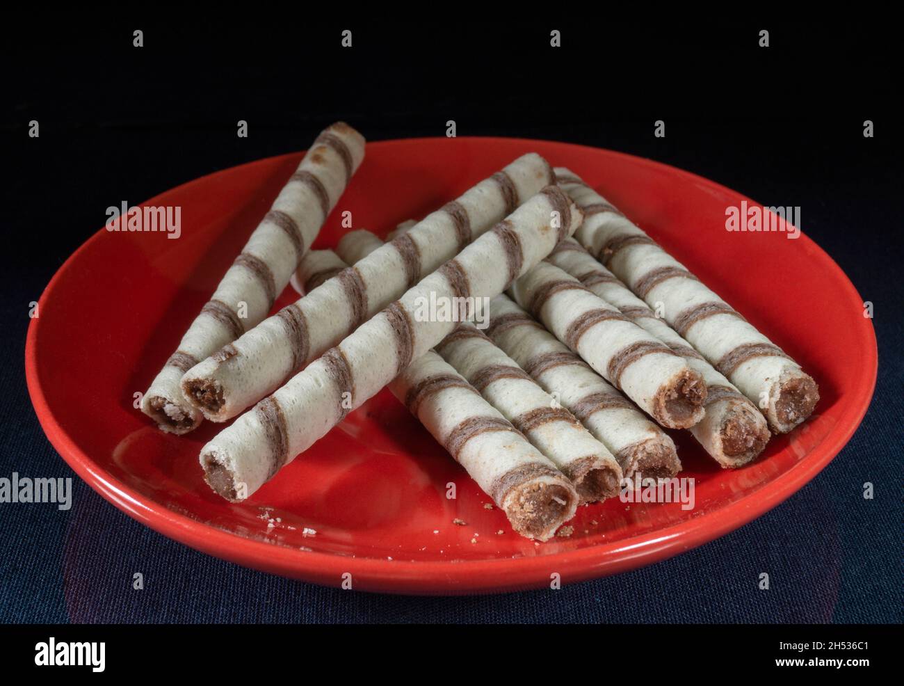 The Sweet sticks with stuffing in red plate on black background ...