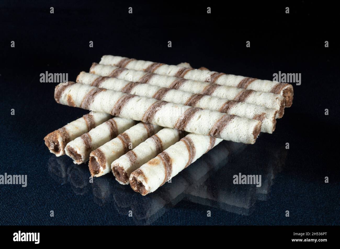 Sweet sticks with stuffing on the table with reflection. Dessert for ...