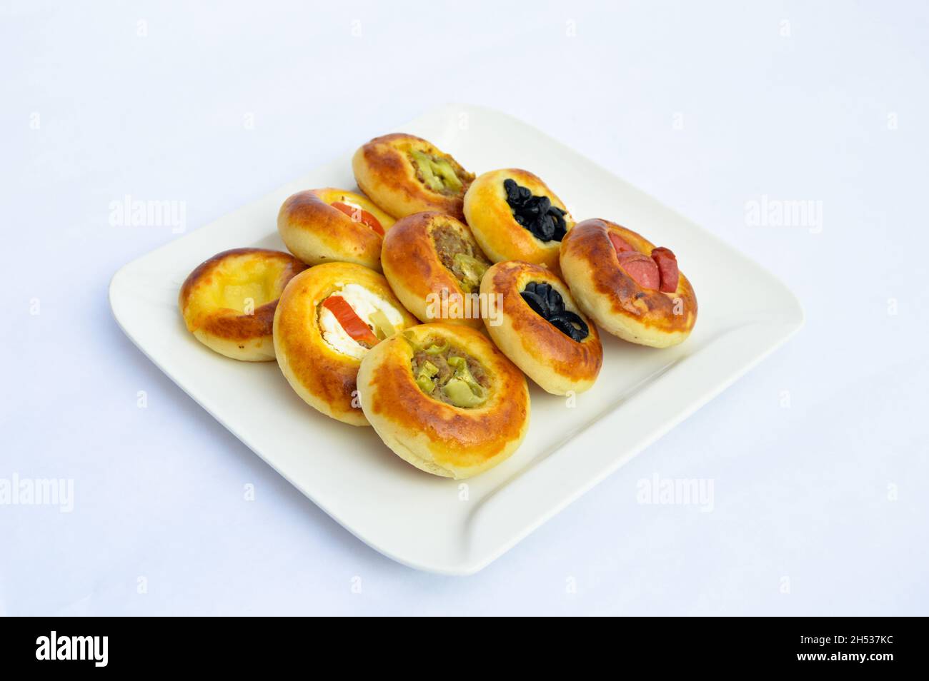 Various tiny delicious mini pizza on a white plate, isolated on white ...