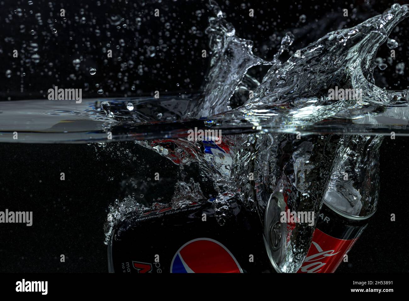 Close up view of can of coca cola, pepsi cola falling into water ...