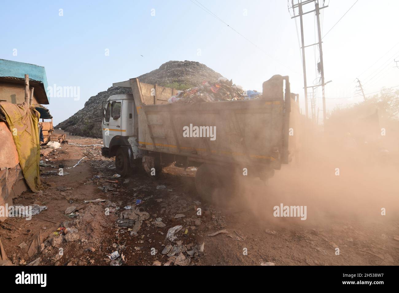 A tipper truck is carrying city waste materials at Belgachia Dump Site ...