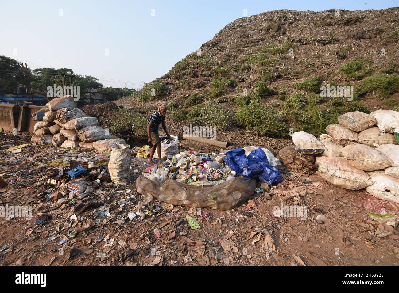 A scavenger man is segregating useful materials from garbage at ...