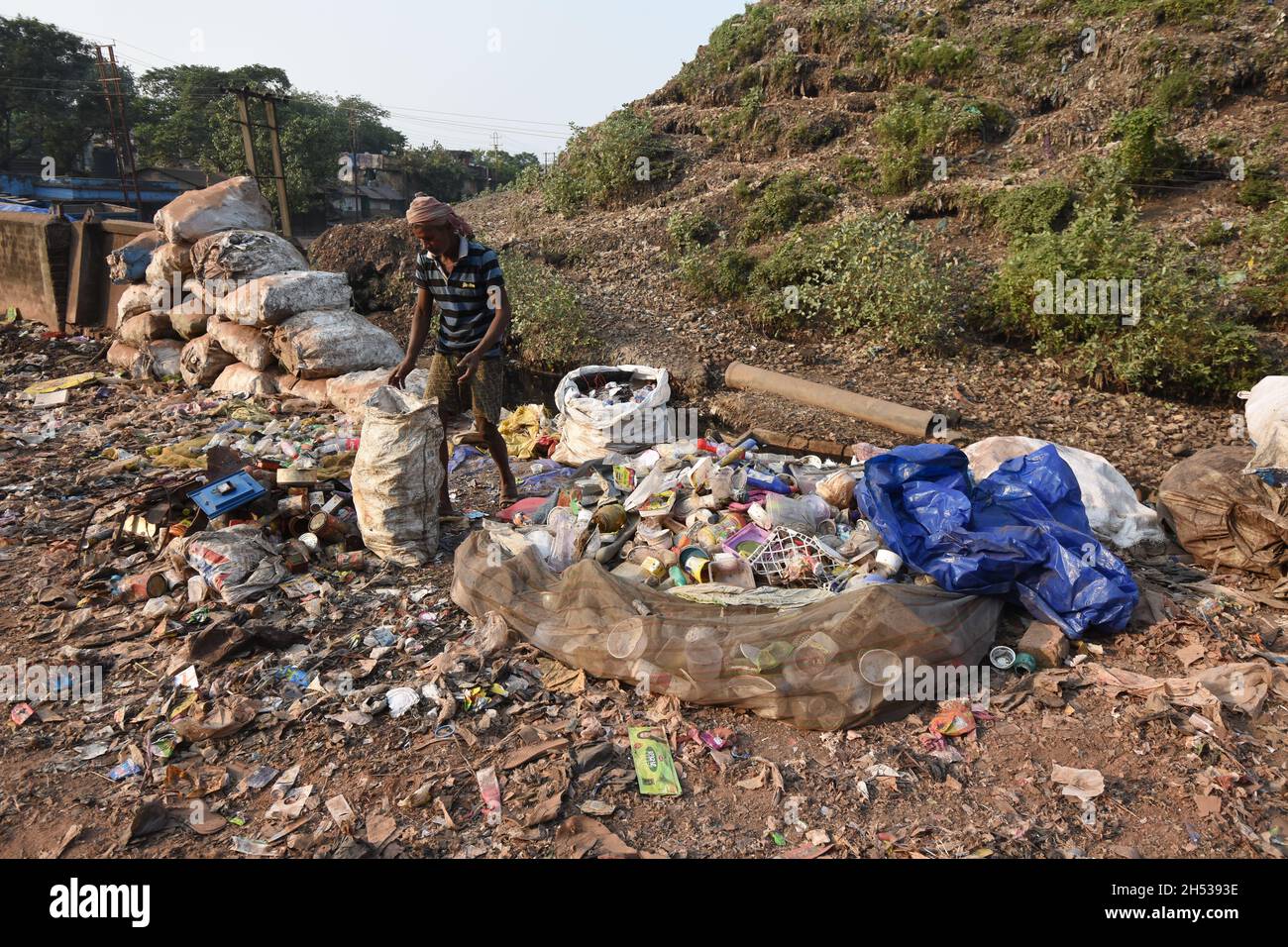 A scavenger man is segregating useful materials from garbage at ...