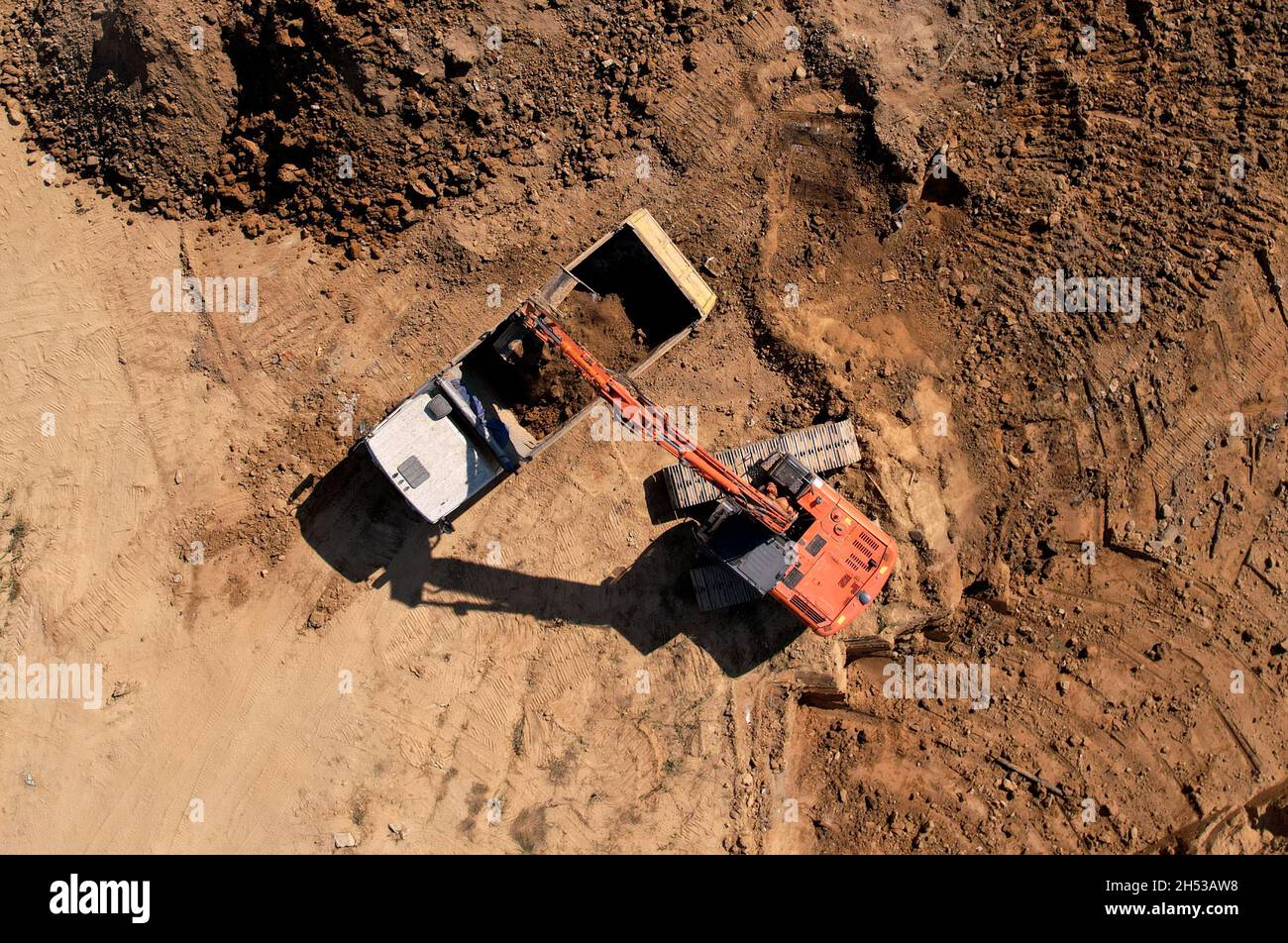 Excavator load the sand into dump truck. Aerial view of an backhoe on ...