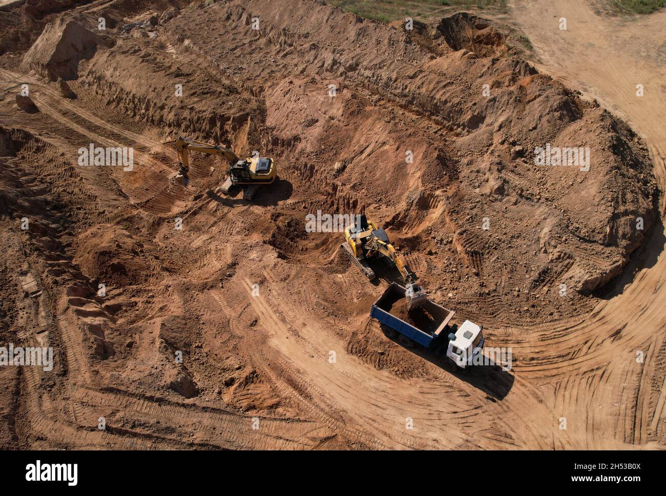 Excavator load the sand into dump truck. Aerial view of an backhoe on ...