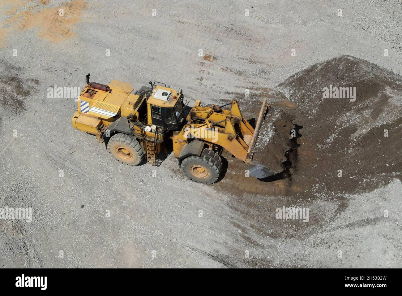 Wheel loader works in a gravel pit. Loading or unloading stone and ...