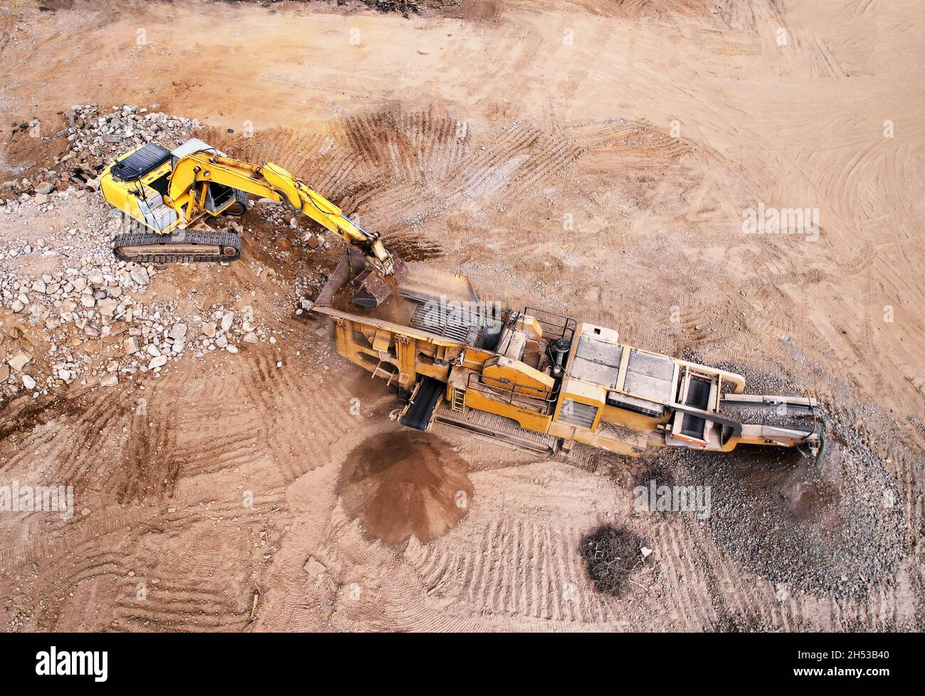 Excavator loading old concrete into stone jaw crusher. Stone crushing ...