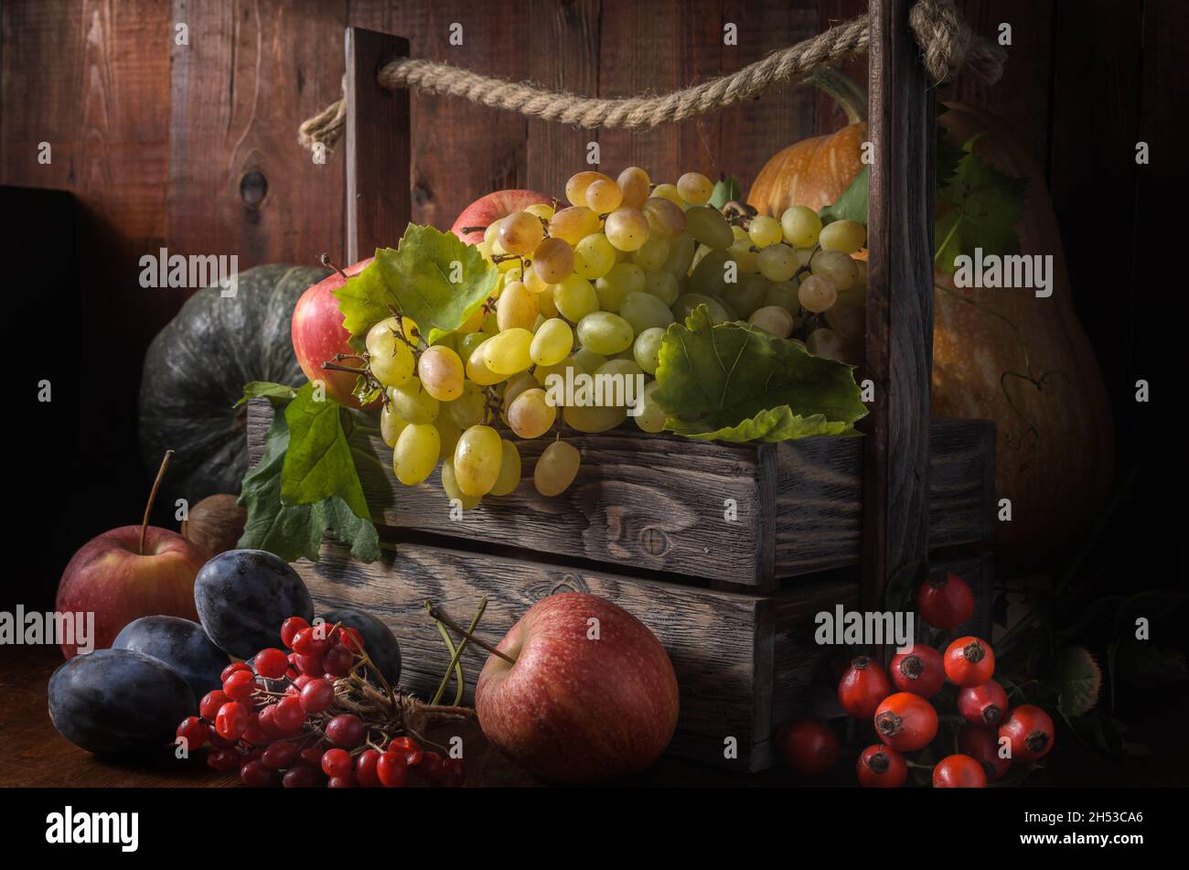 grapes and other fruits on a dark wooden background in a rustic style ...
