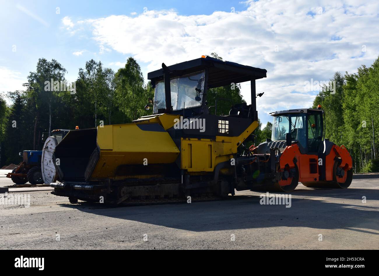 Asphalt paver machine during road work. Road roller at construction ...