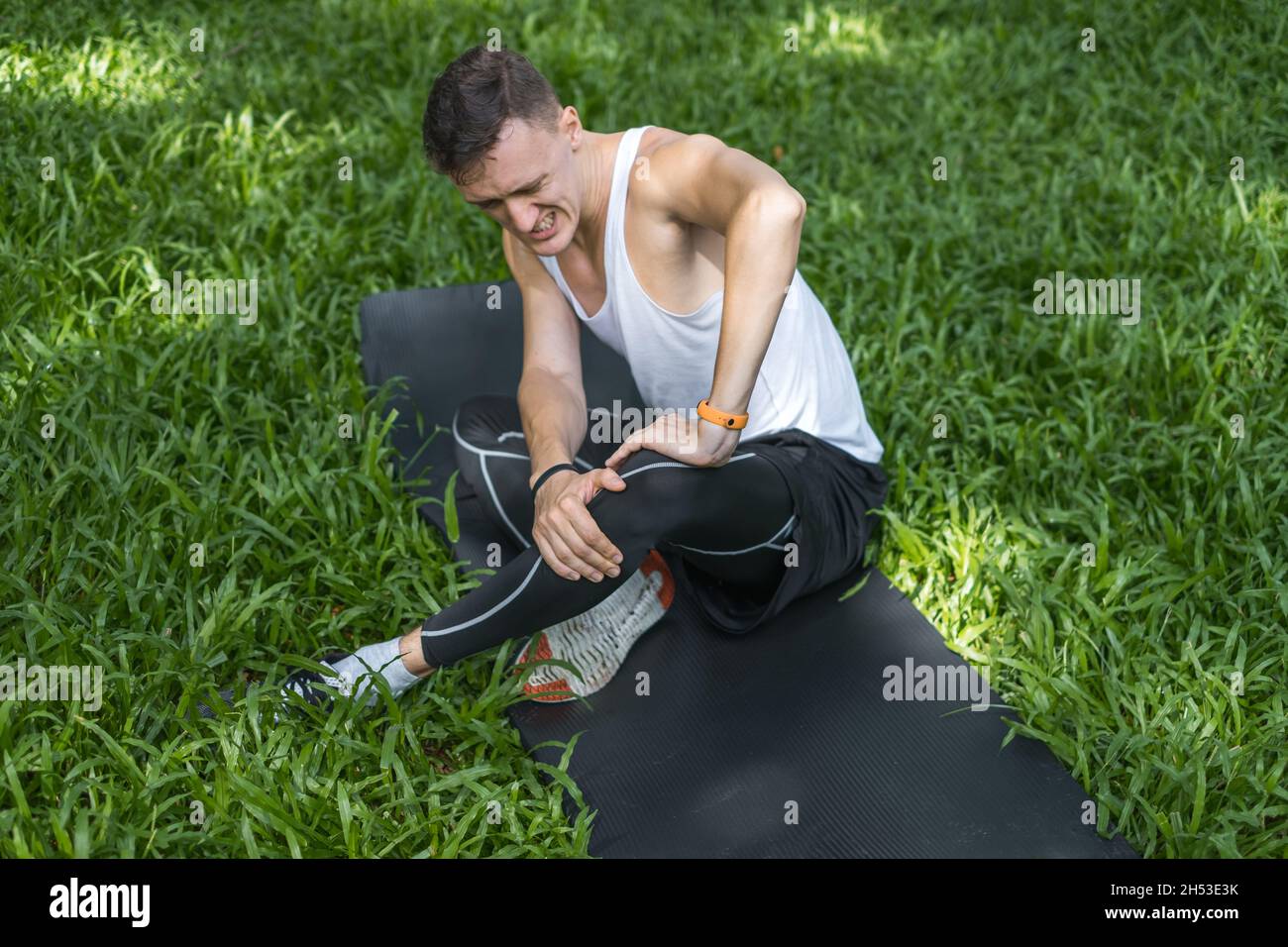 Portrait of man touching his leg with his hand. Man injured his knee ...