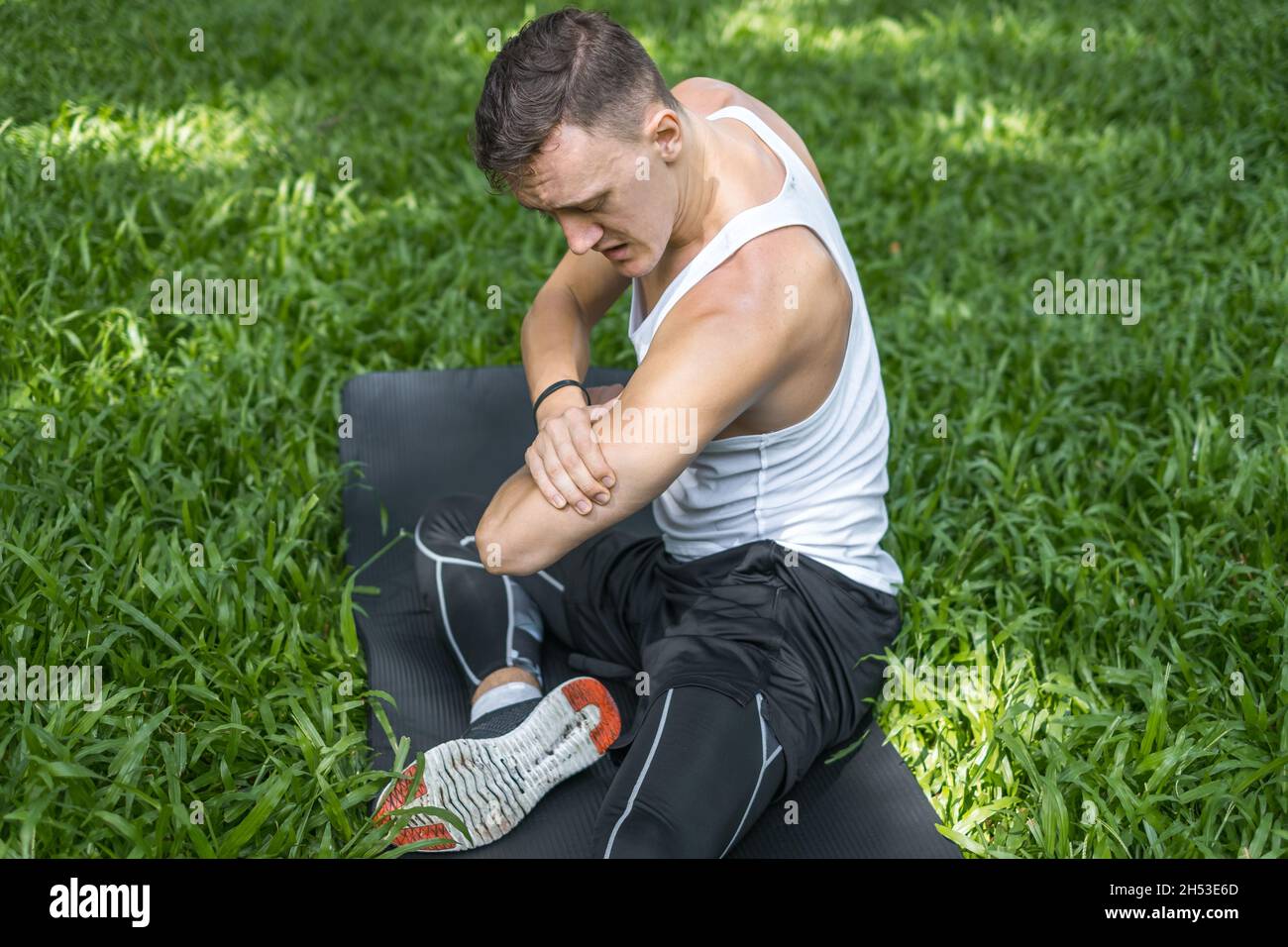 Close up portrait of man touching his arm with his hand. Man injured ...