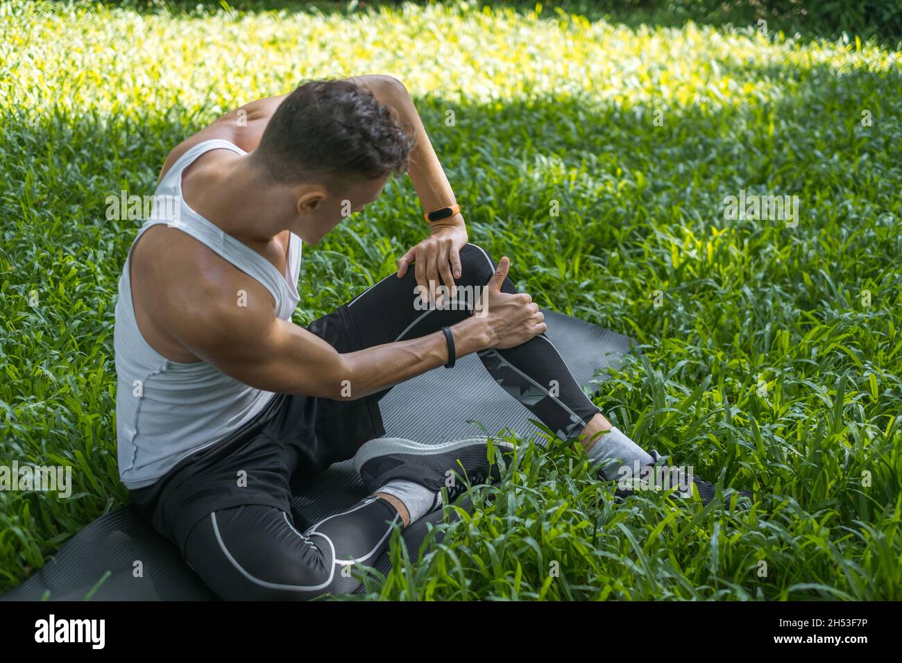 Portrait of man touching his leg with his hand. Man injured his knee ...