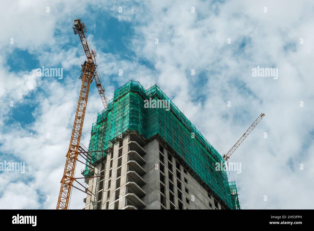 Building of a skyscraper with the crane against the sky and clouds ...
