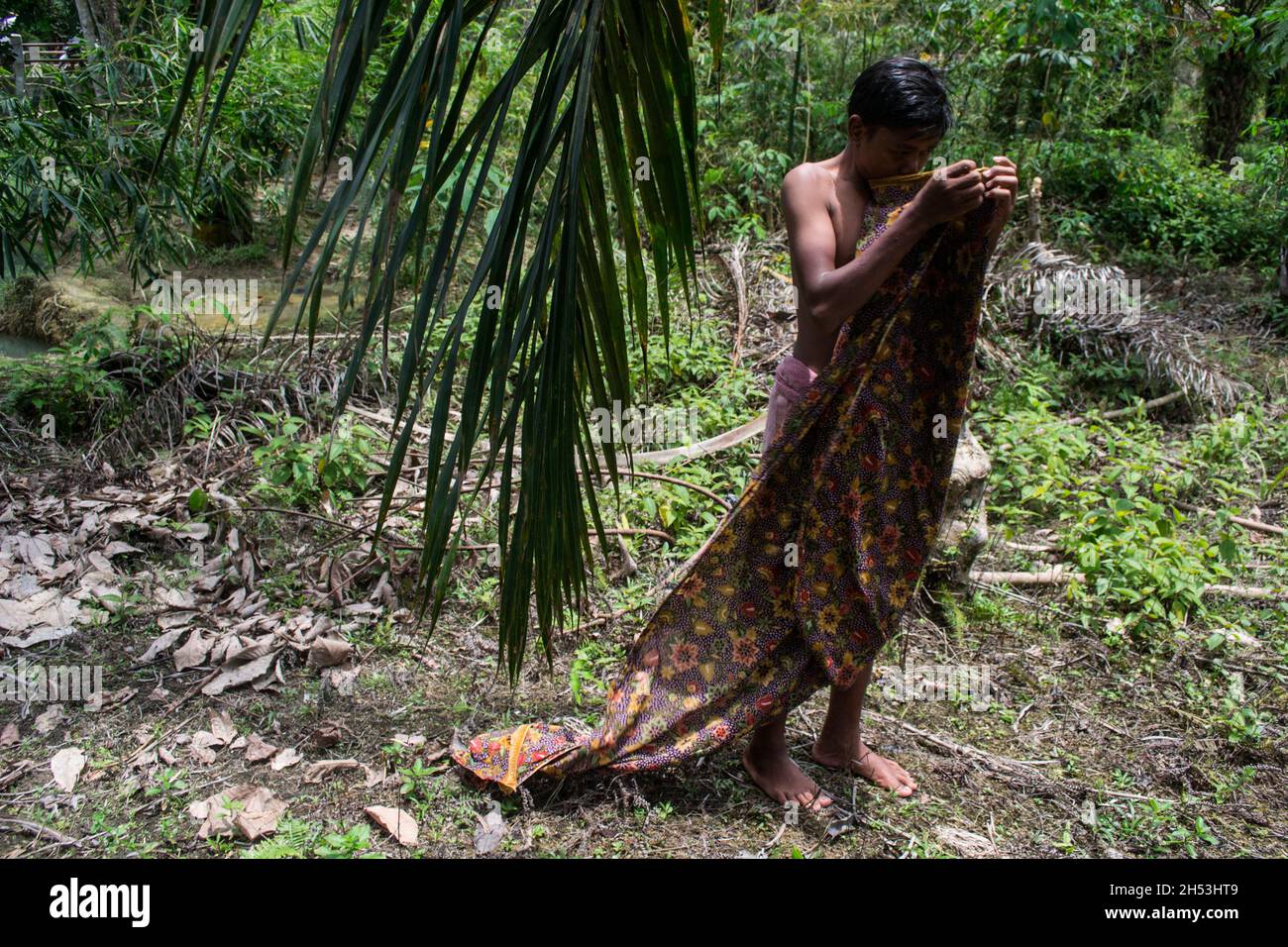 A Suku Anak Dalam or Jungle People children, Gumedek is seen changing ...