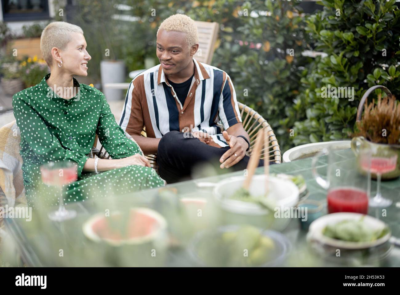 Multiracial couple having dinner at their backyard Stock Photo - Alamy