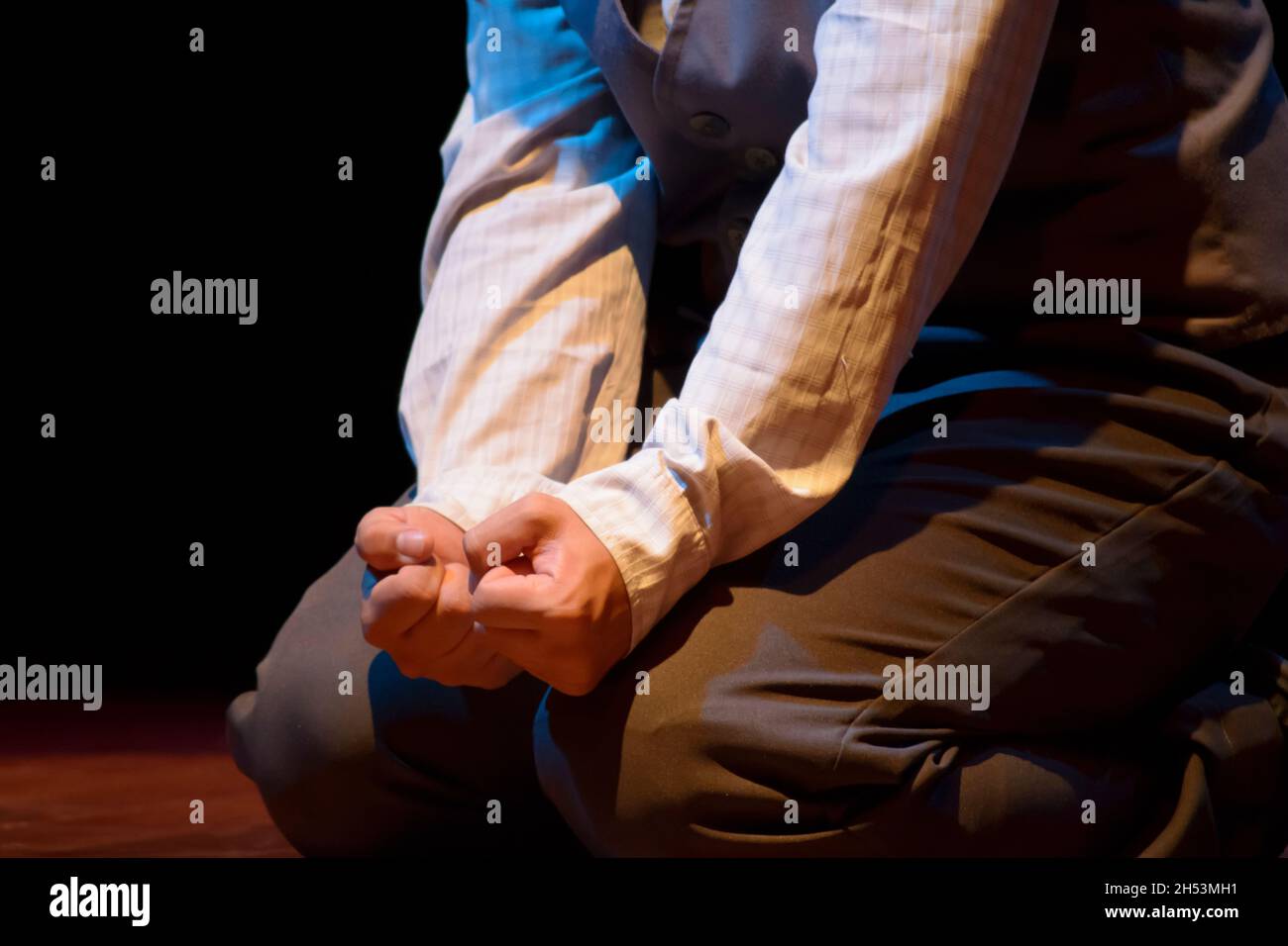Actor representing a character on theater. He clenches his hands in ...
