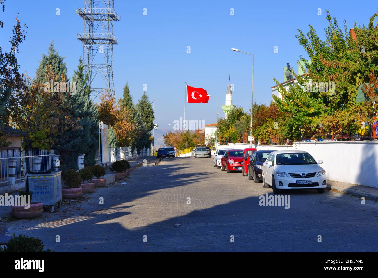 Cars Parked at a Regular street in Turkey with Turkish flag and minaret ...