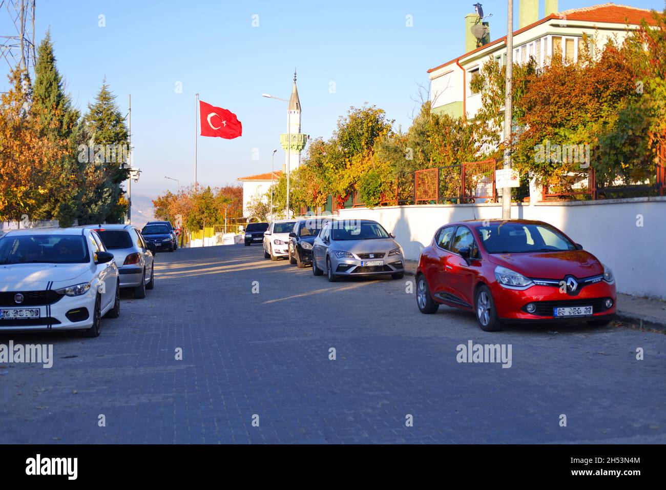 Cars Parked at a Regular street in Turkey with Turkish flag and minaret ...