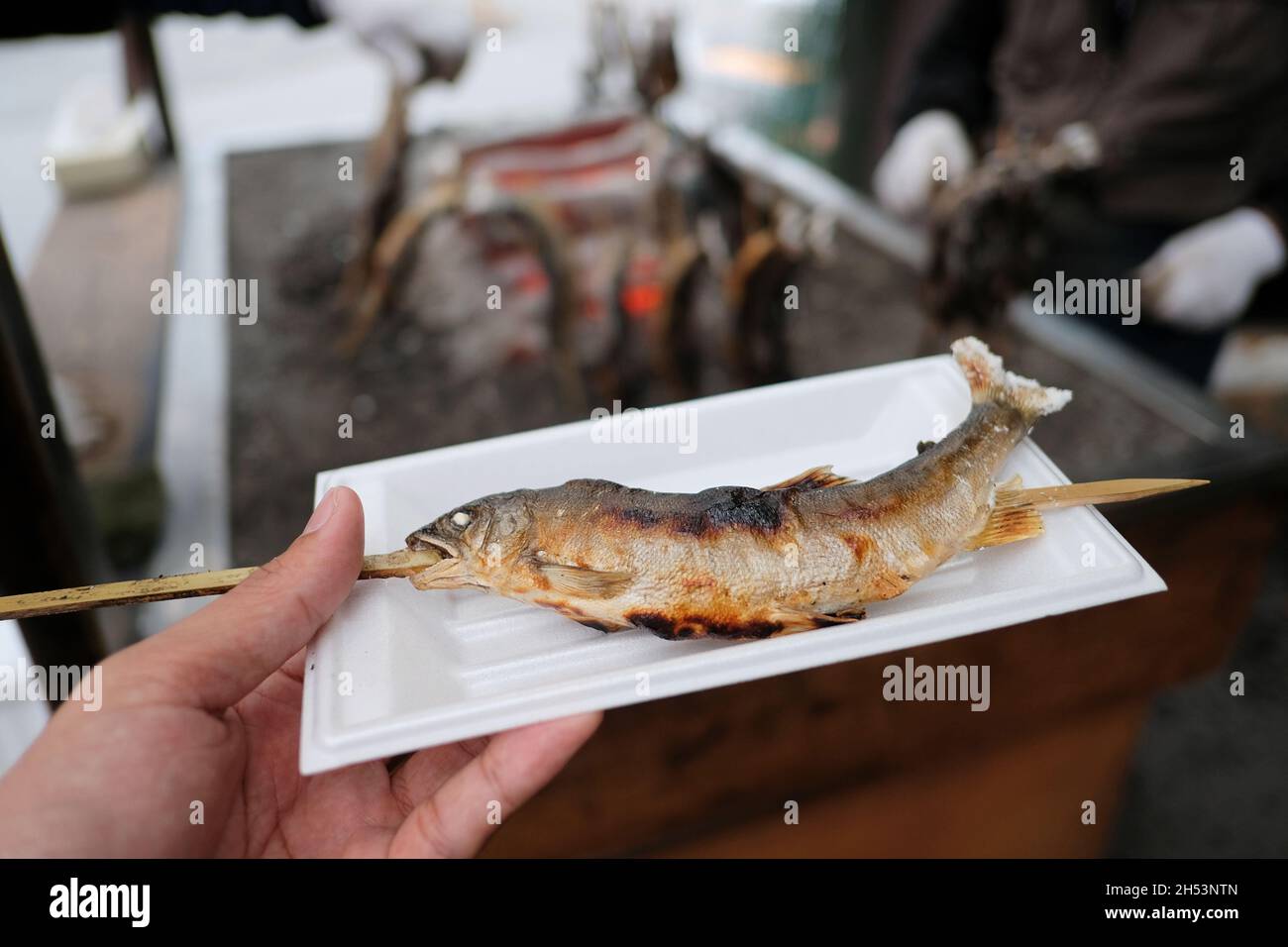 Charcoal grilled Ayu fish with salt in white plate. Traditional ...