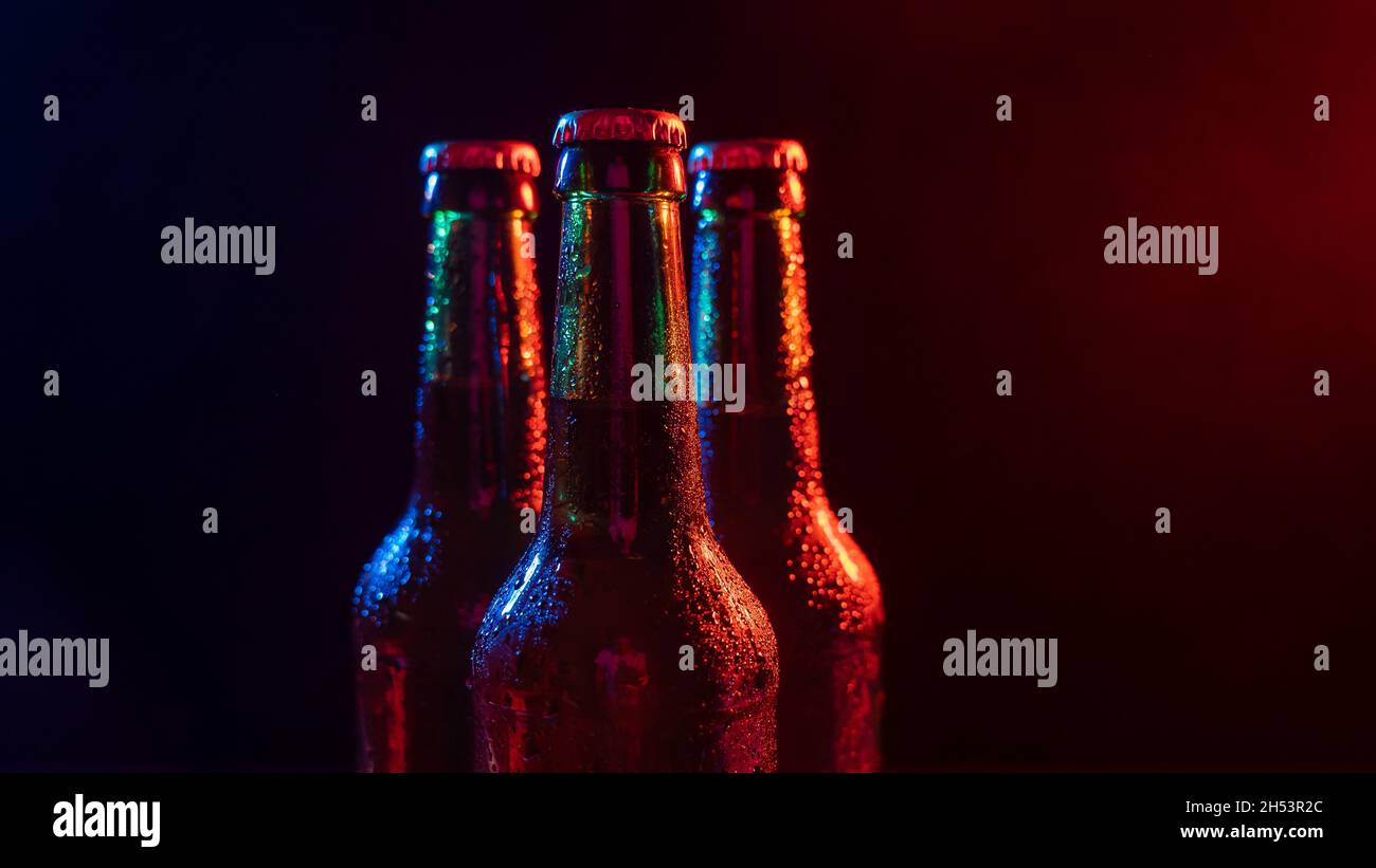 Three bottles of beer in a blue-pink mist Stock Photo - Alamy
