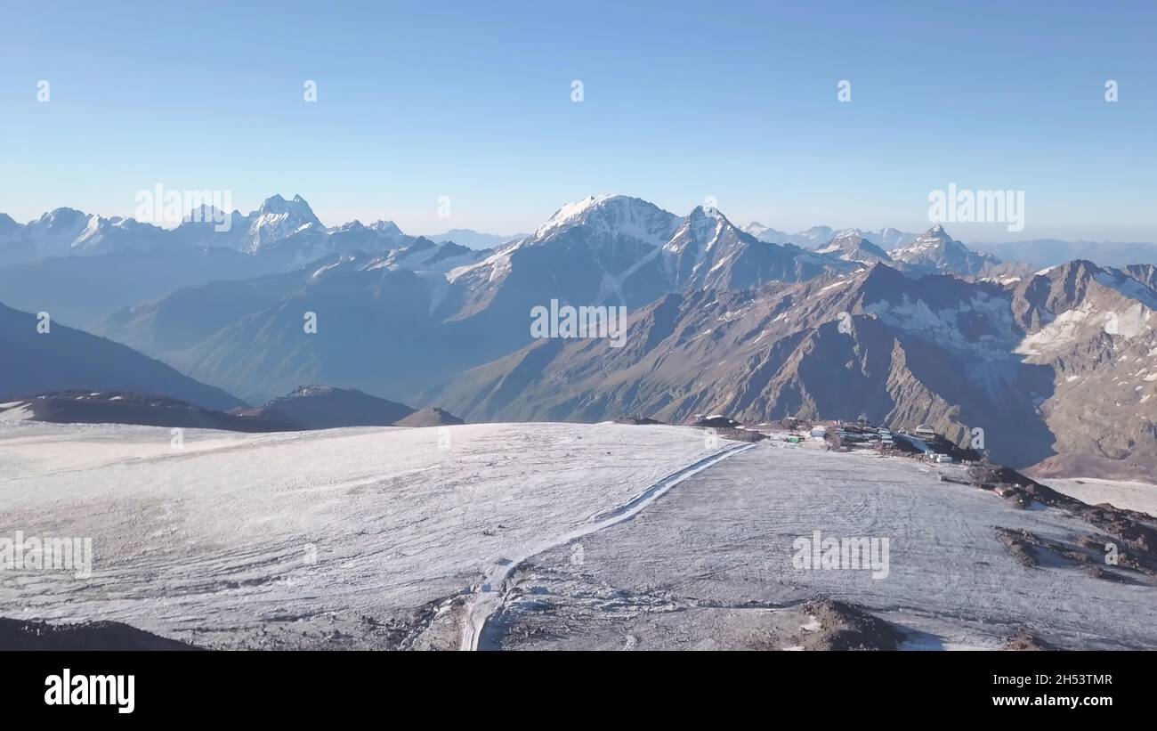 Snowmobiles and houses in snowy mountains. Clip. Top view of snowcats ...