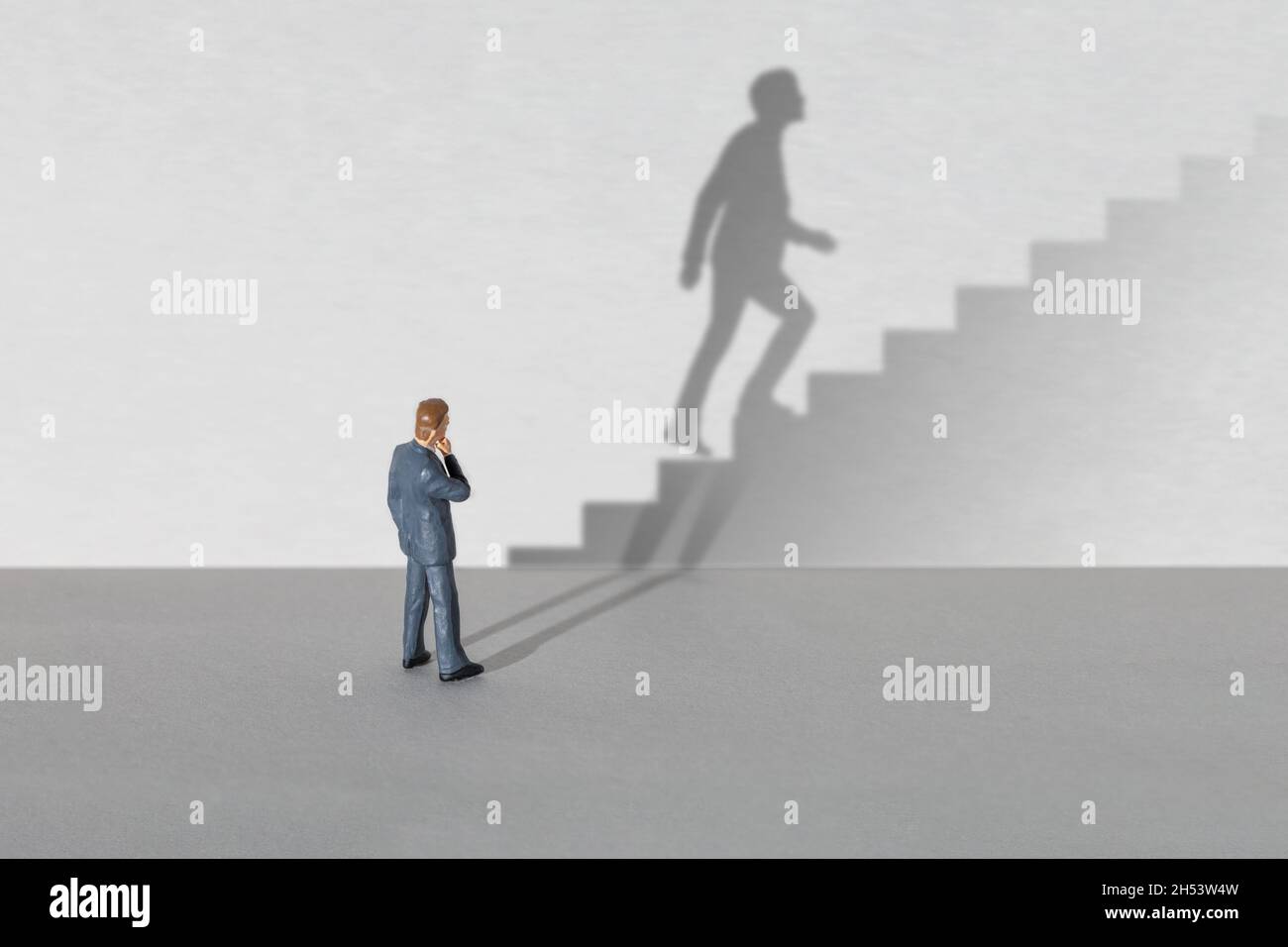 Career. Businessman is planning a career growth, the shadow symbolizes ...